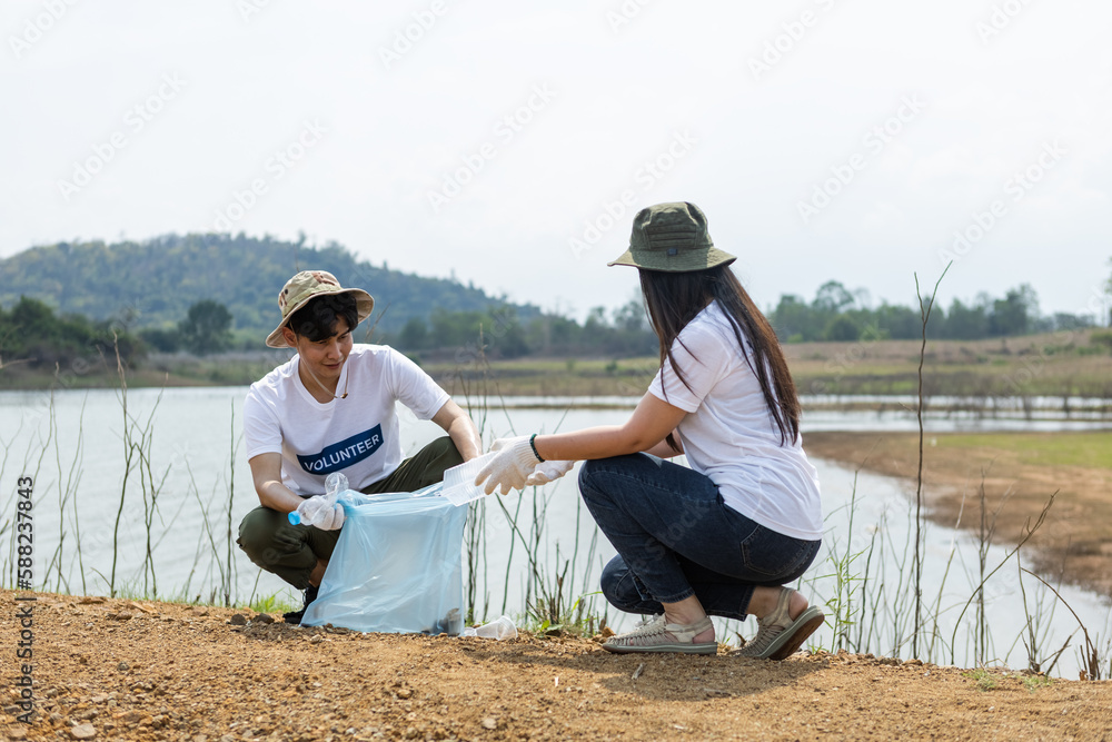 Foto Male and female volunteers collecting garbage, conducting ...