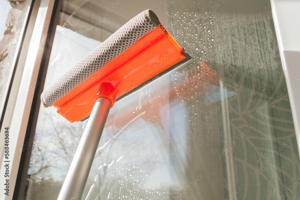 Window washing. Cleaning the window with a brush and foam. The concept ...