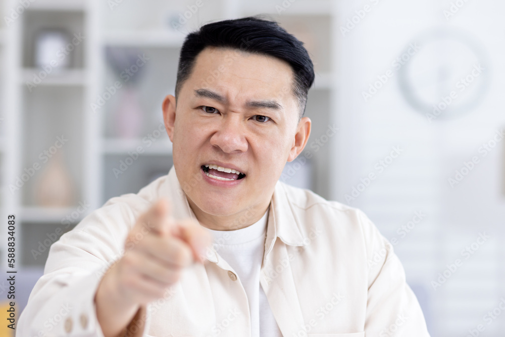 Video call online meeting, mature adult asian looking at camera angry ...