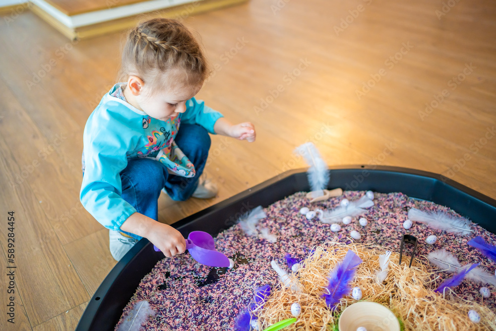 Little girl playing with sensory colorful rice. Sensory development and ...