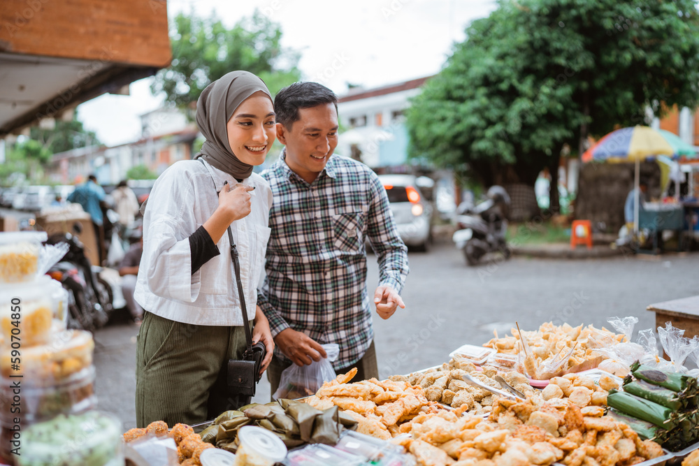 beautiful muslim couple are shopping in a food stall or street vendor ...