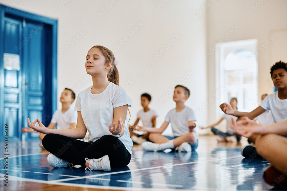 Schoolgirl and her classmates meditating while exercising Yoga on ...