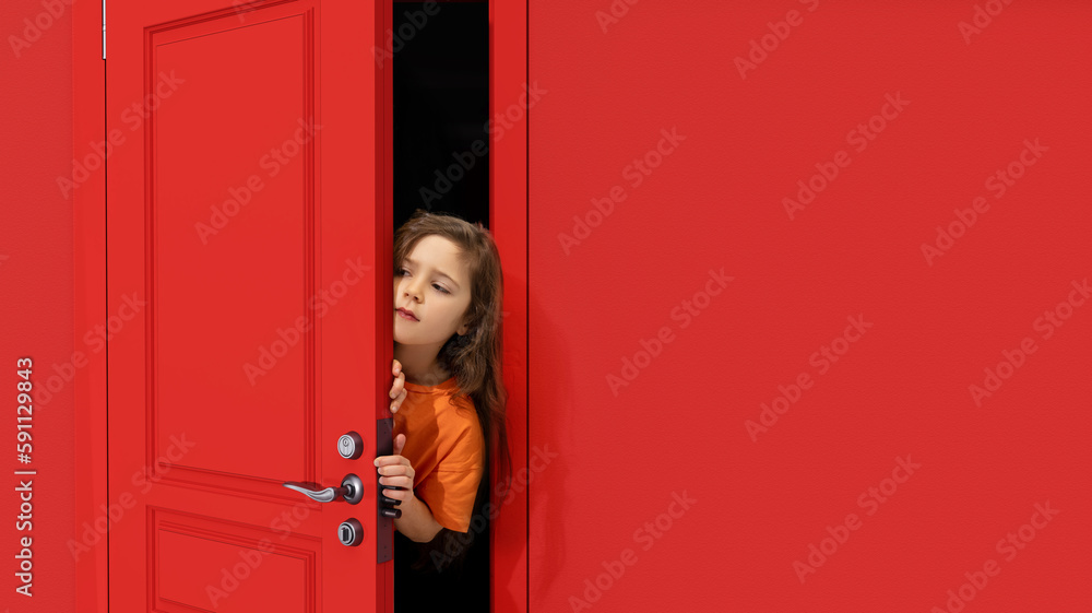 Stock-Foto „Portrait of young little girl, kid peeking out red door and ...