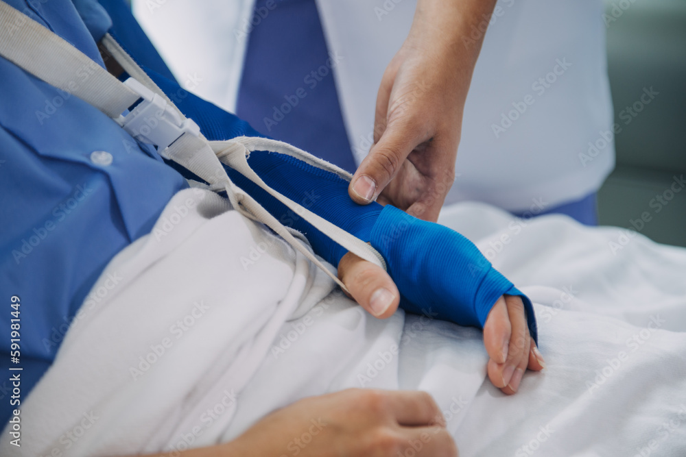 Injured patient showing doctor broken wrist and arm with bandage in ...