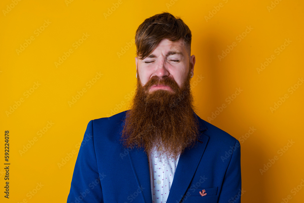 Dismal gloomy rejected red haired man wearing blue suit over yellow ...