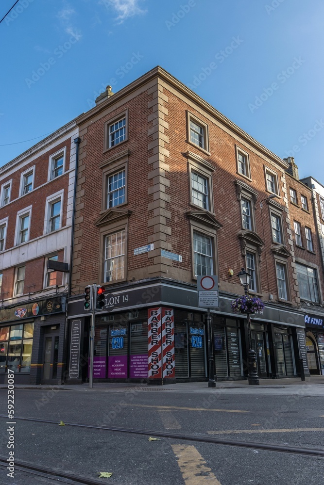 Corner street with brick buildings in the city of Dublin and traffic ...