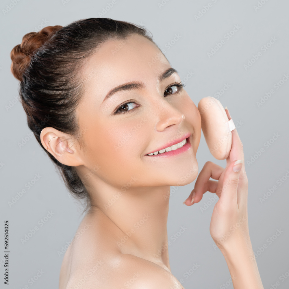 Glamorous beautiful female model applying cushion powder for facial ...