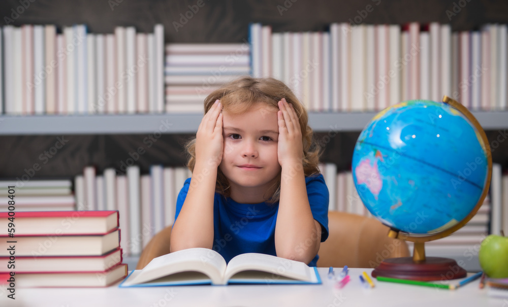 Elementary schoolboy. Little student on school library. Kid reading ...