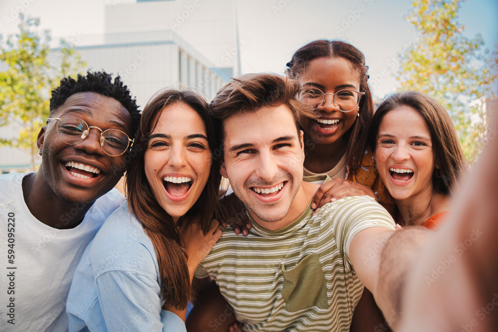 Happy multicultural friends laughing taking a selfie portrait together ...