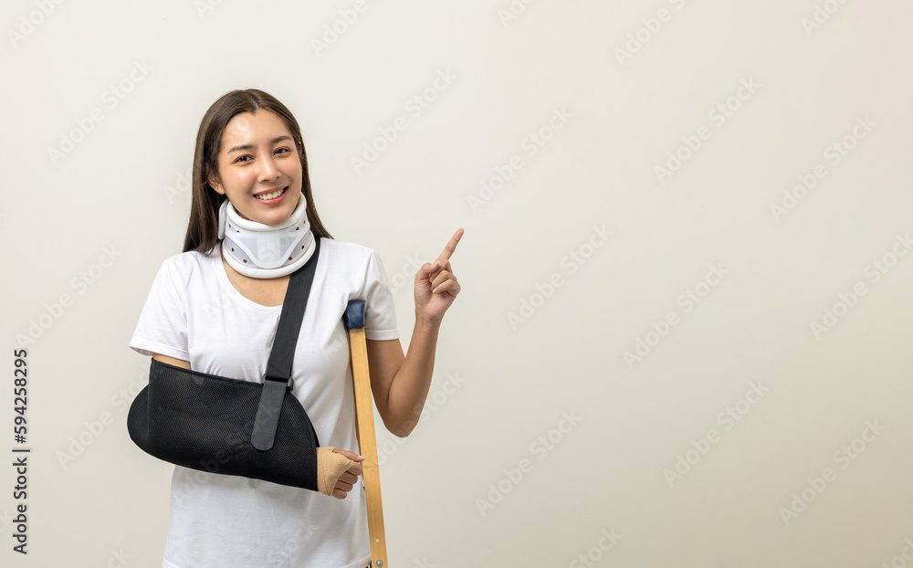 Happy young asian woman broken arm pointing finger on isolated ...