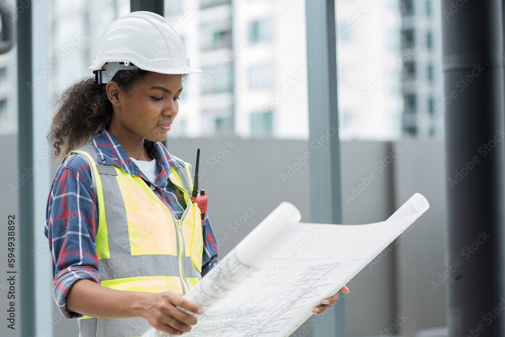 Female engineer worker working, holding blueprint and inspecting ...
