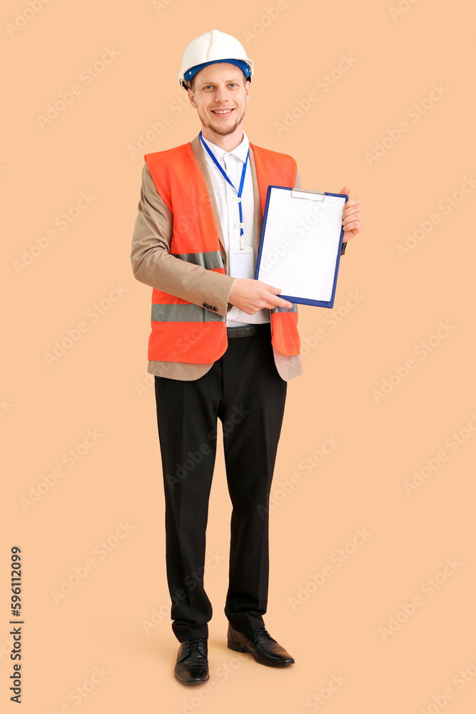 Male architect with clipboard on beige background Stock Photo | Adobe Stock