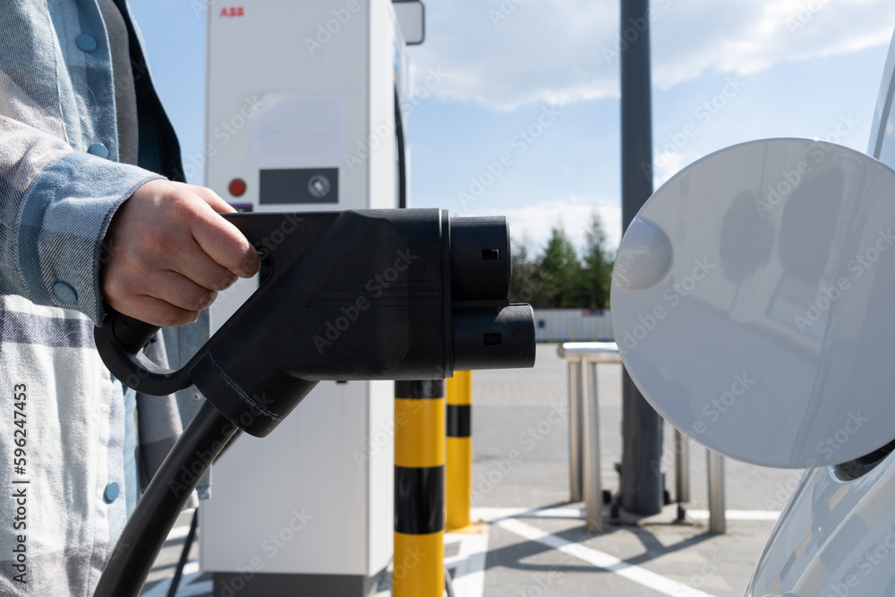 Foto de Stock Woman holding CCS fast charging socket type 2. Combined ...