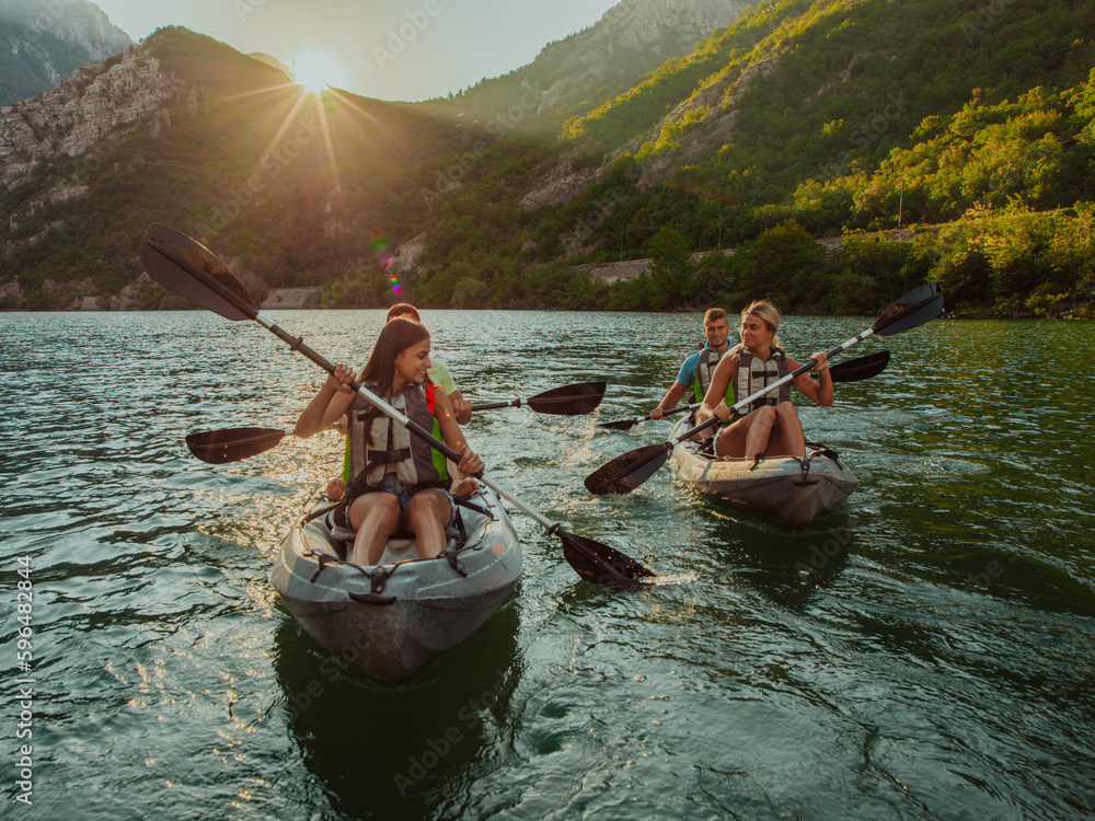 A group of friends enjoying fun and kayaking exploring the calm river ...
