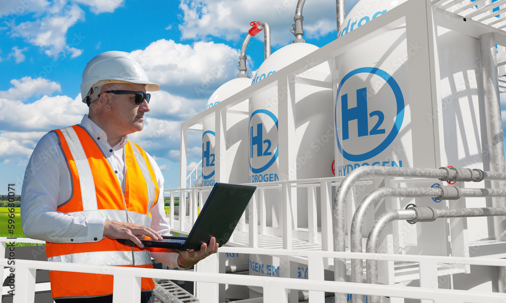 Man technologist of hydrogen factory. Industrial tanks with h2 logo ...