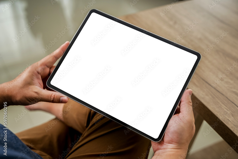 A businessman holds a mockup. iPad digital tablet with blank screen ...