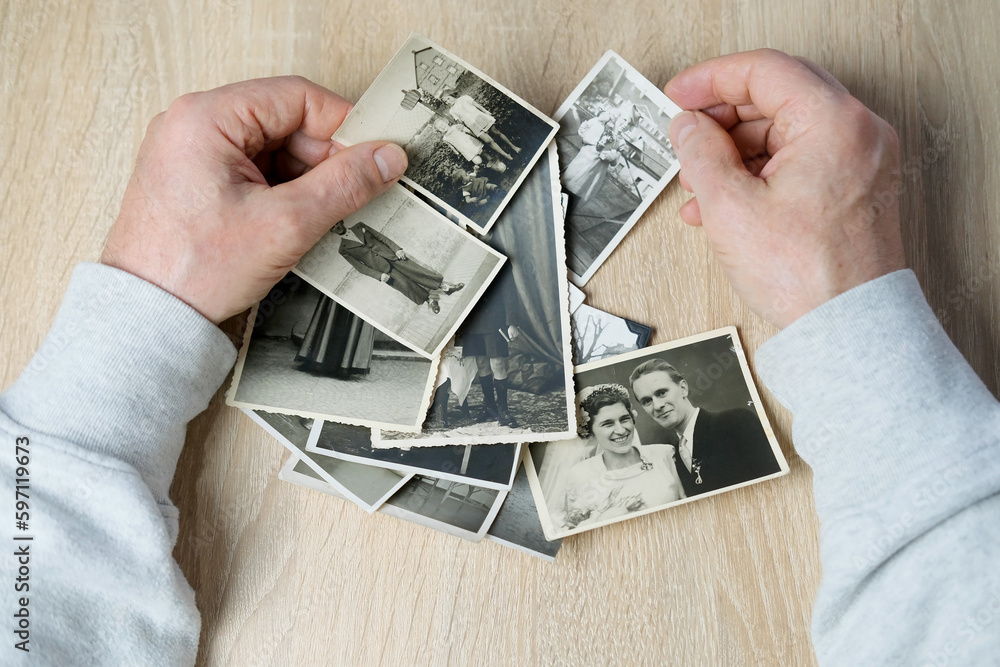 an elderly man looks through his old photographs of 1950-1955, the ...