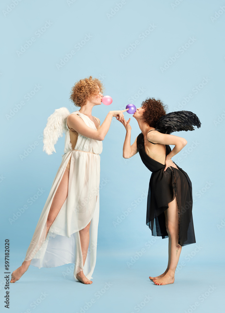 Tandem of evil and kindness. Portrait of two beautiful young women in ...