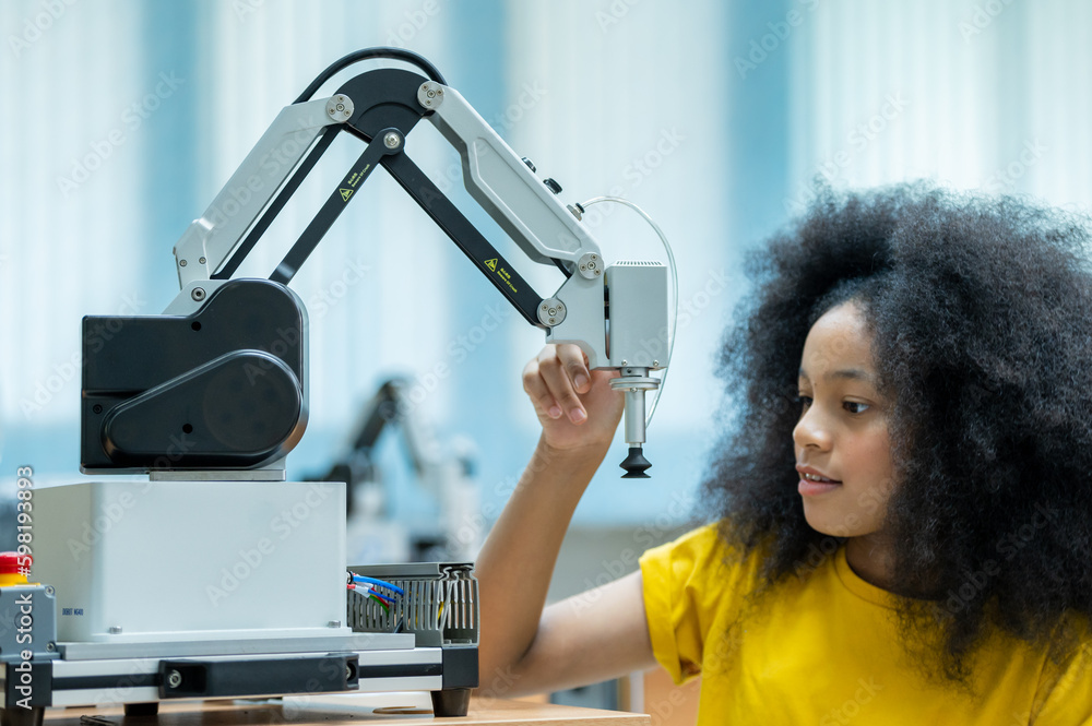 Foto Kid female teen child enjoy Machine Learning Robot arm is Moving ...