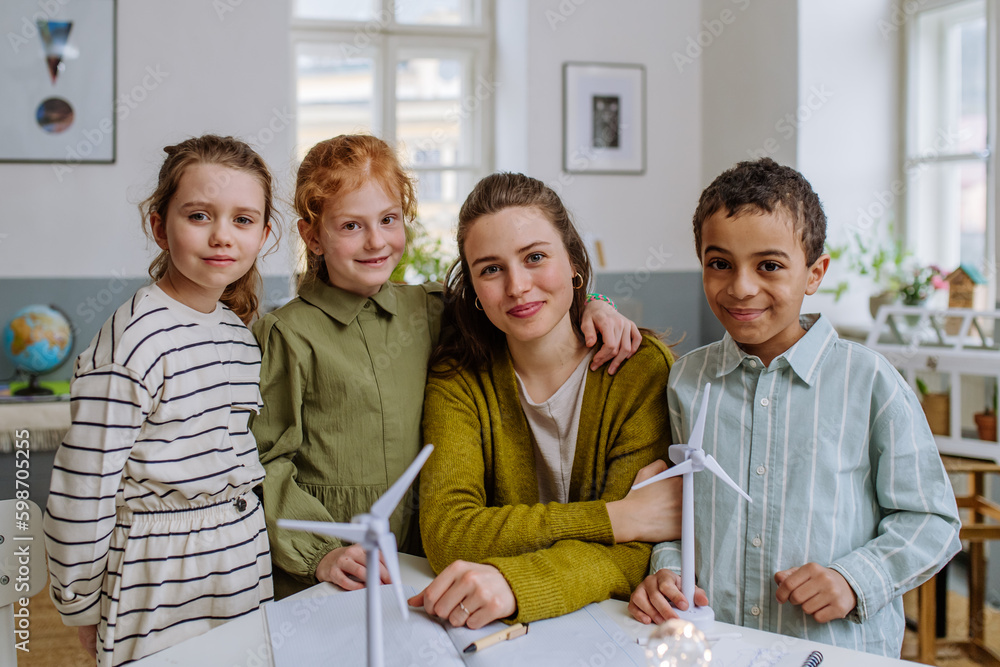 Foto de Stock Young teacher with model of wind turbine learning pupils ...