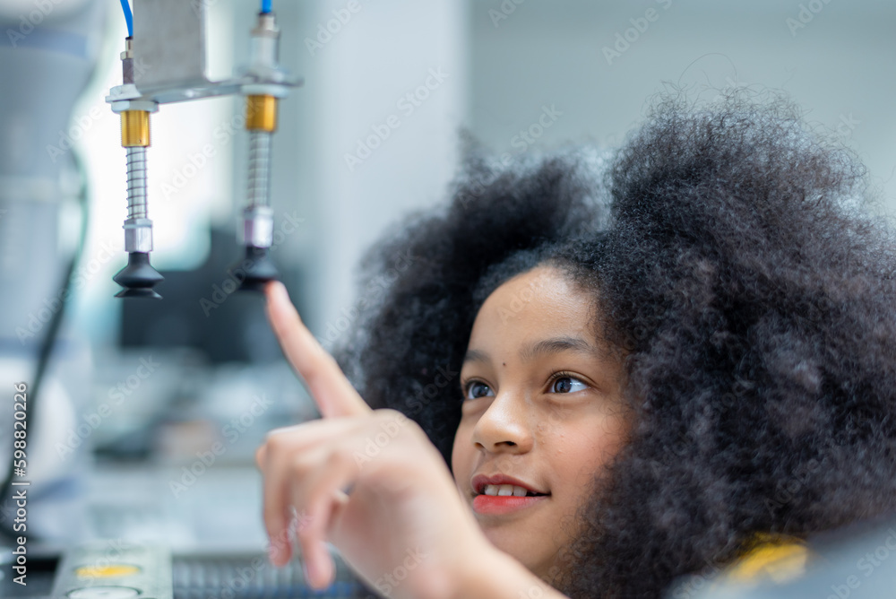 Foto Kid female teen child enjoy Machine Learning Robot arm is Moving ...