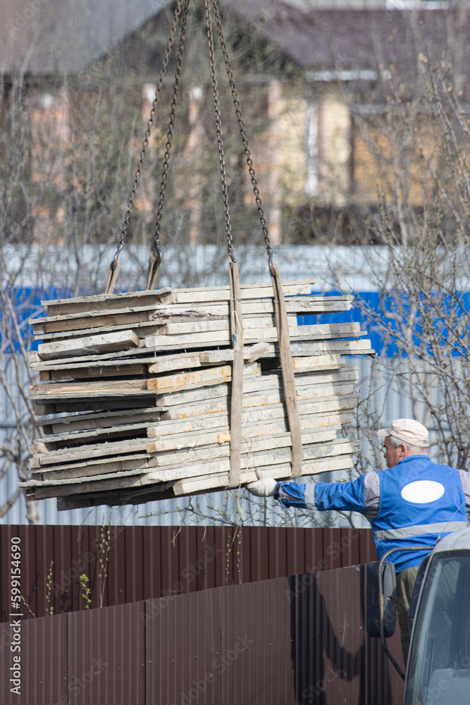 construction workers loading wooden structures with a crane Stock Photo ...