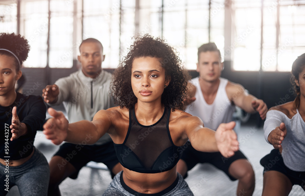 Strong glutes activated. a group of young people doing squats together ...