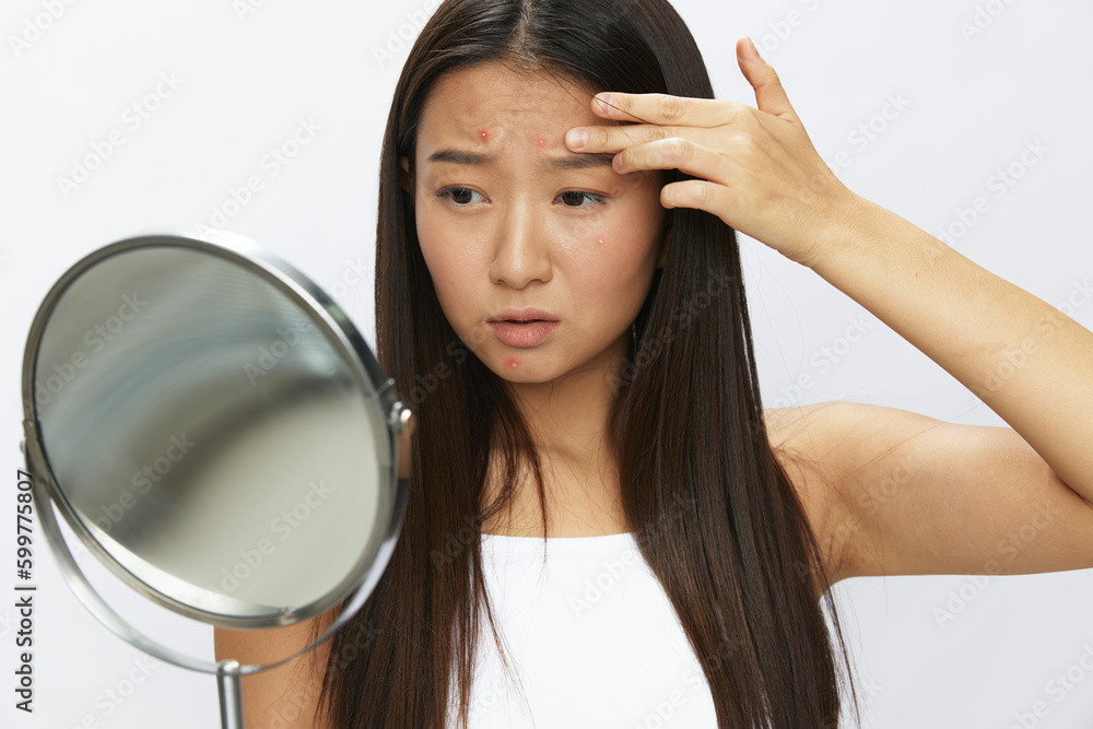 Asian woman with mirror in hand facial skin problems, acne and ...
