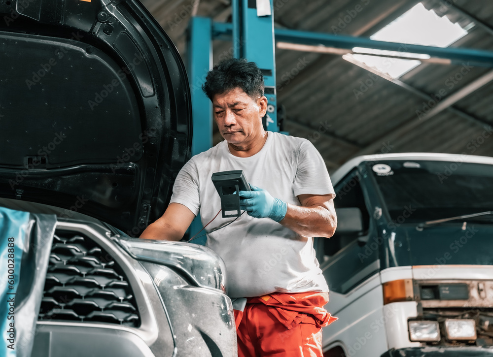 Experienced auto mechanics inspect car battery terminals and voltage to ... Experienced auto mechanics inspect car battery terminals and voltage to ...