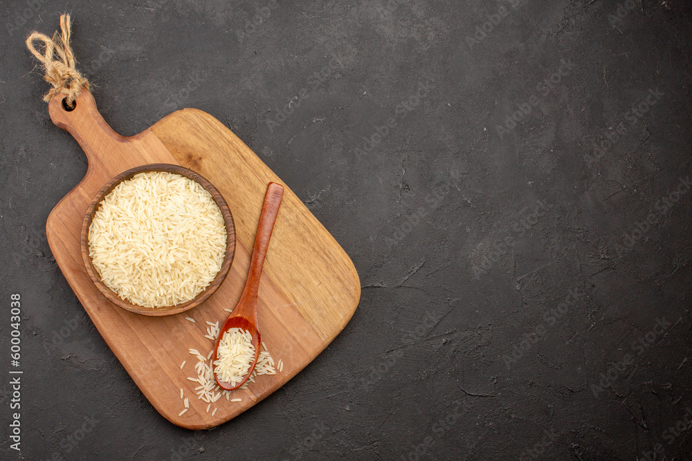 top view raw rice inside wooden brown plate on the grey background rice ...