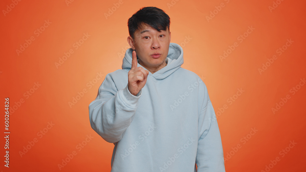 Asian handsome man shakes finger and saying No, be careful, scolding ...