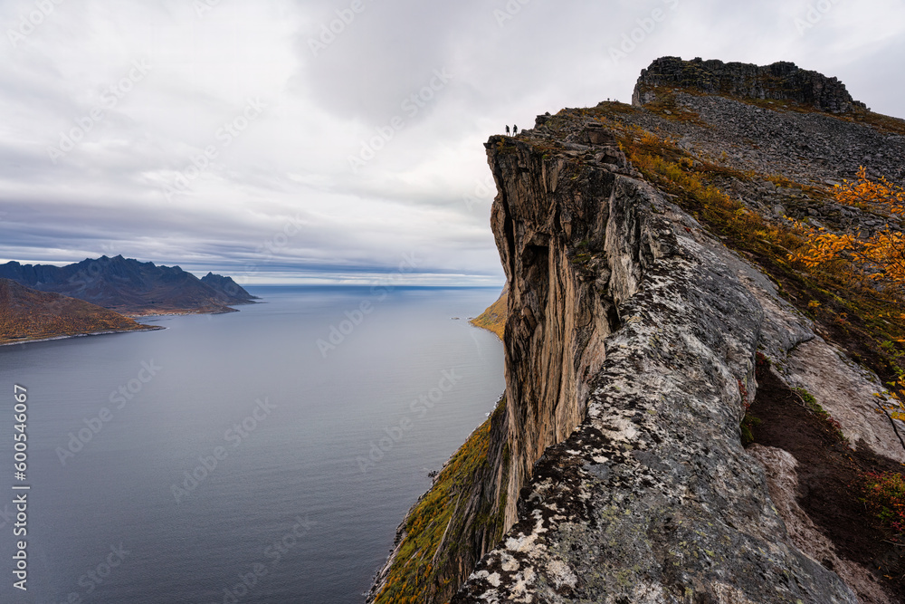 People looking over the Mefjorden fjord from a very high cliff leading ...