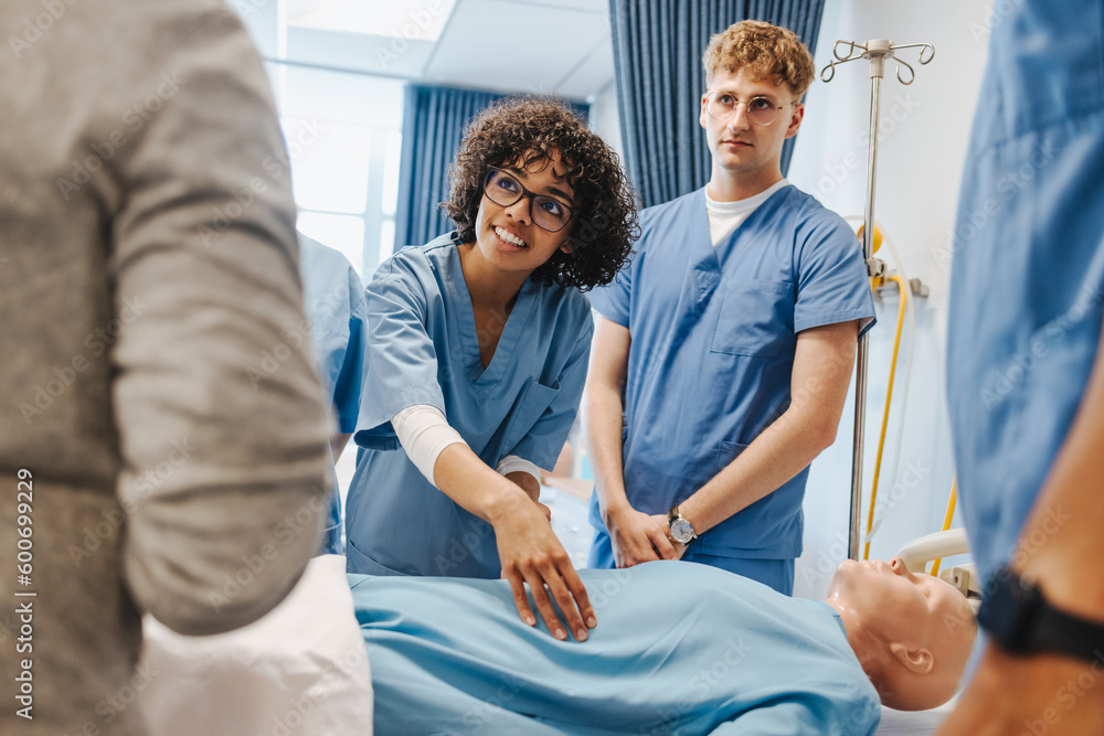 Students wearing scrubs receive medical training in a clinical ...