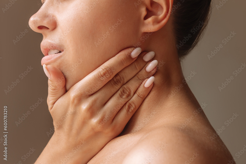 Photo Stock Inflamed tonsillar lymph nodes. Young woman touches ...