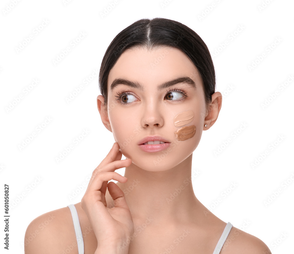 Teenage girl with swatches of foundation on face against white ...