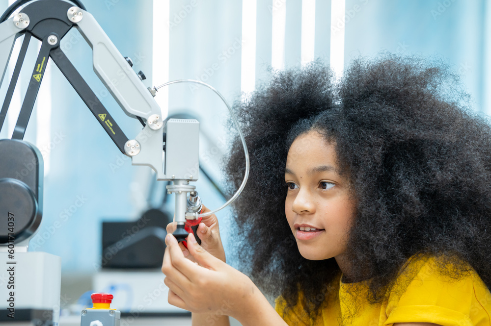 Foto Kid female teen child enjoy Machine Learning Robot arm is Moving ...