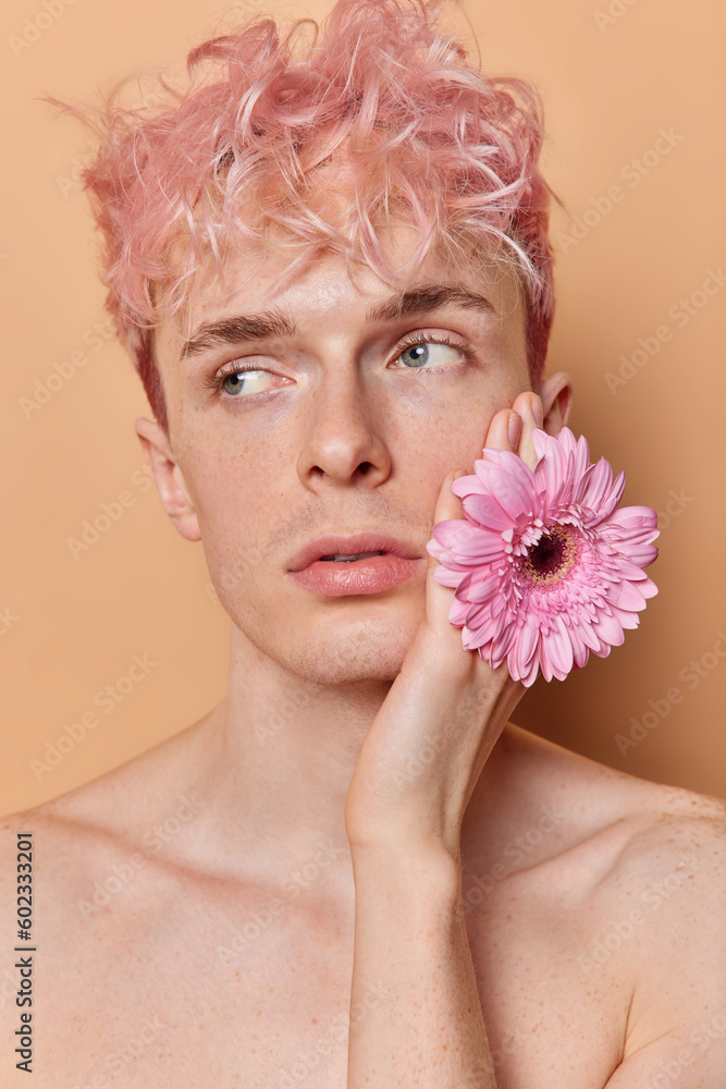 Vertical image of thoughtful pink haired man holds gerbera flower near ...