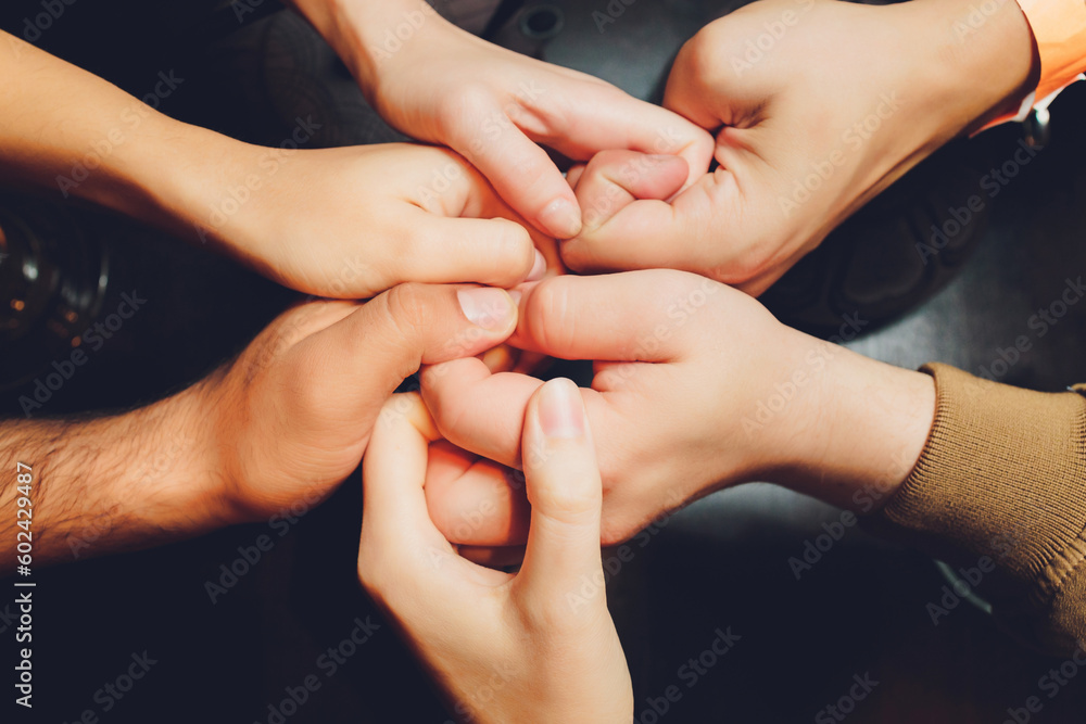 two man and three women holding hands on a table implying a polyamory ...