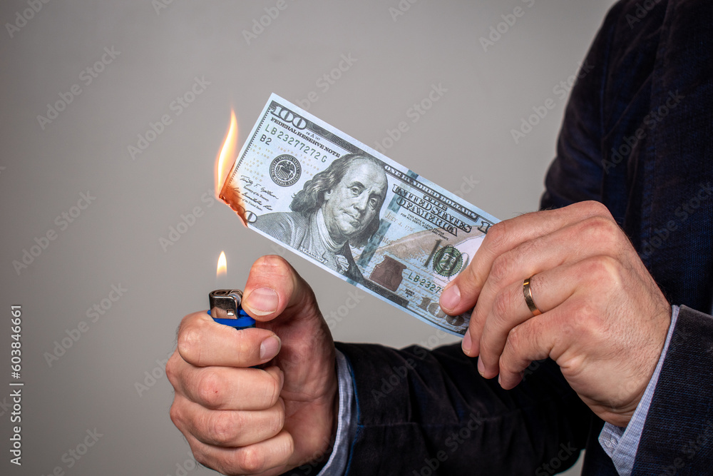 Persona prendiendo fuego un billete de 100 dolares en concepto de ...