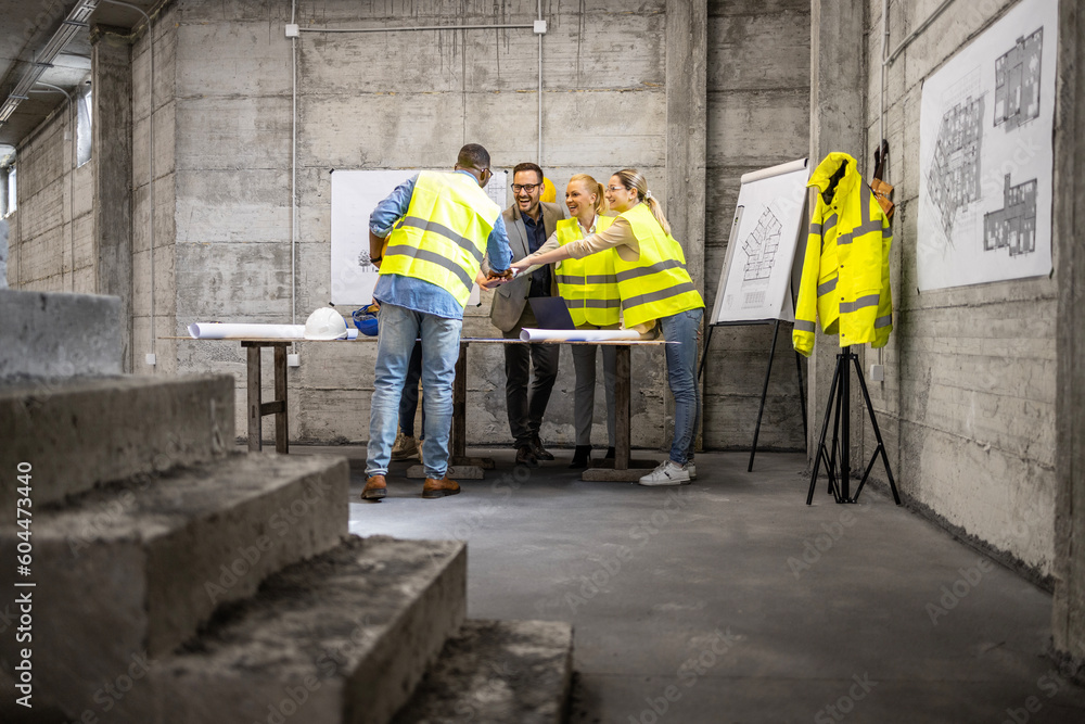 Team of structural engineers and architects holding hands together ...