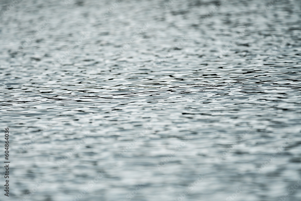 surface of water showing ripples as squiggles and pattern in light and ...