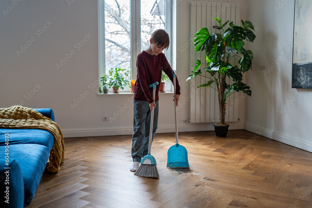 Household chores for children. Schoolboy child sweeping floor. Kid boy ...