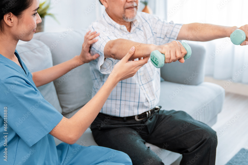Contented senior patient doing physical therapy with the help of his ...