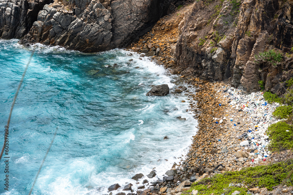 waves hit the rock at beach, sea water splash up to the sky with sun. A ...