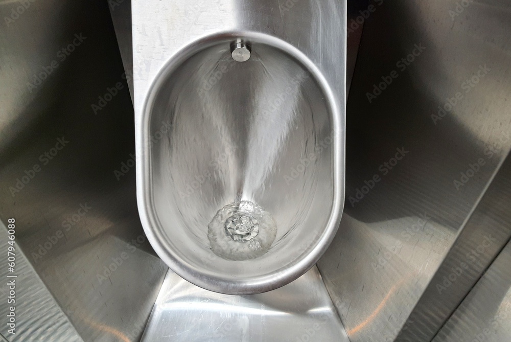 Sanitary metal urinal, toilet bowl in public bathroom with hygienic ...