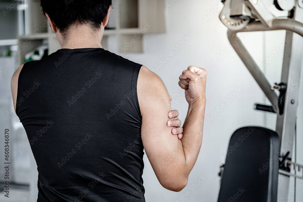 Sportive man feeling upper arm muscle pain after doing weight training ...