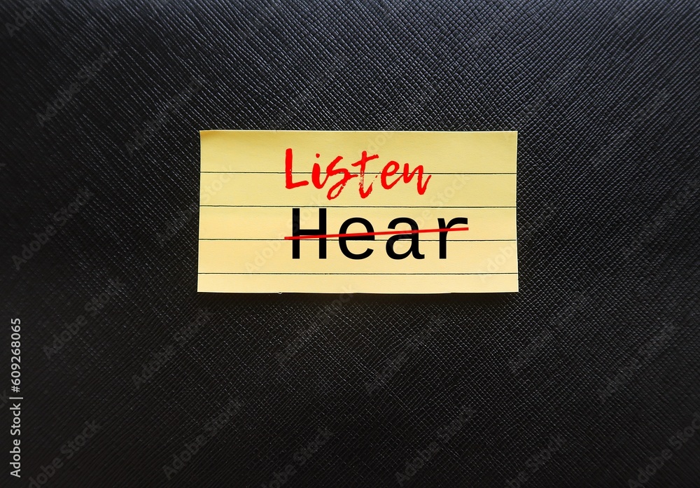 Yellow note on black background with handwritten text HEAR crossed off ...