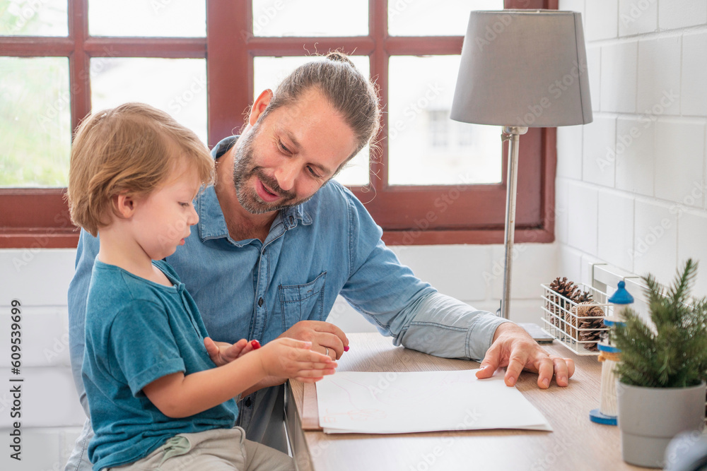 Father and child paint together. Dad teaches his son how to paint ...