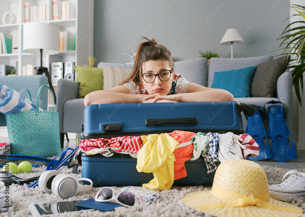 Exhausted sad woman packing her luggage Stock Photo | Adobe Stock