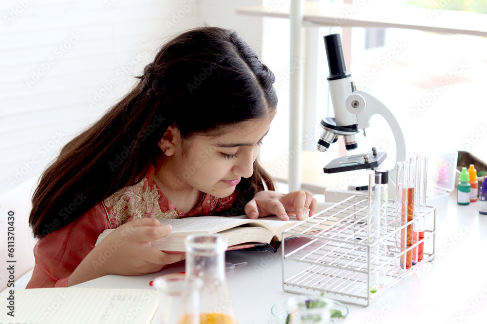 Cute Indian school girl in India traditional dress costume reading book ...